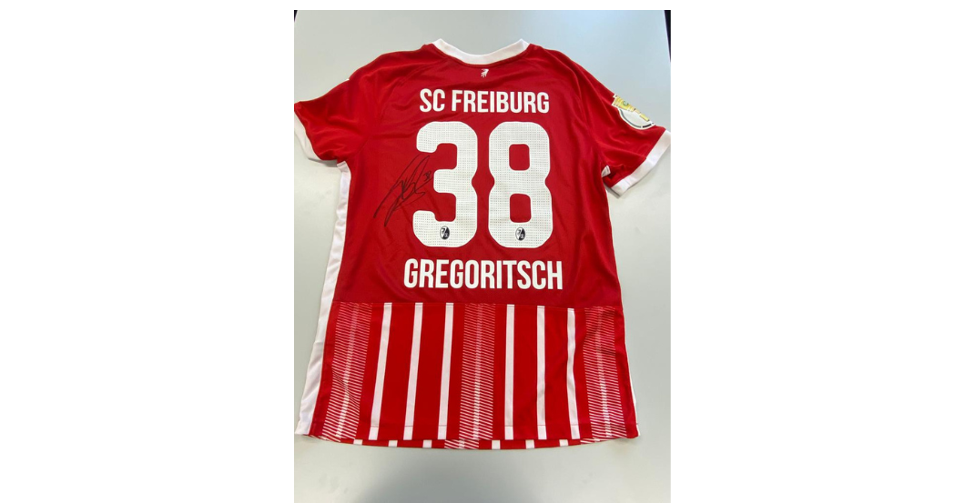 Torjäger Michael Gregoritsch signiert sein SC Freiburg-Trikot