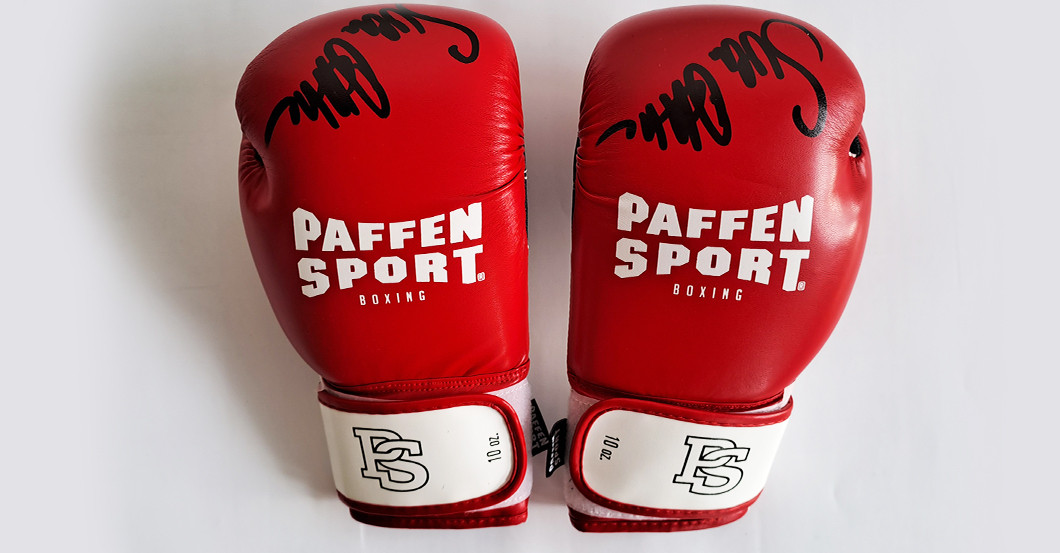 Box-Weltmeister Sven Ottke signiert rote Boxhandschuhe