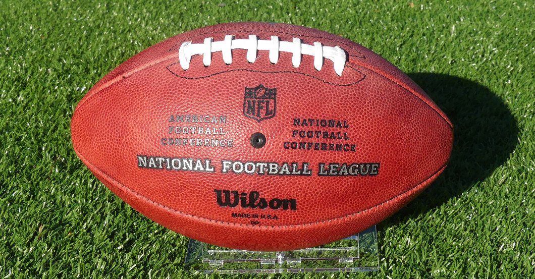 NFL-Legende Sebastian Vollmer signiert einen Football