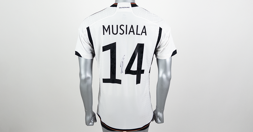 DFB-Star Jamal Musiala signiert sein Spielertrikot